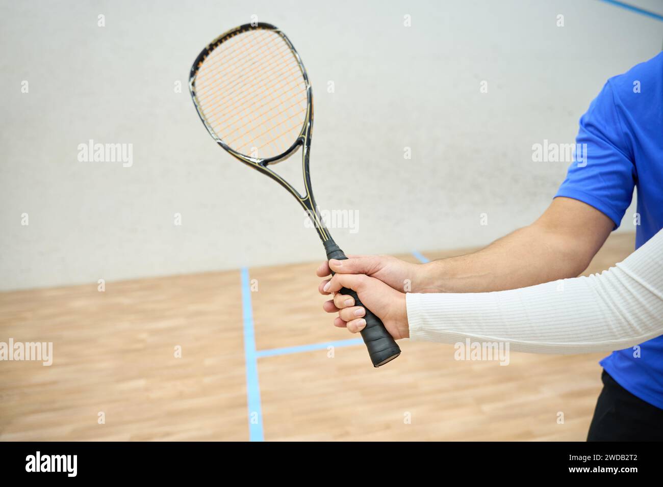 Unrecognizable man teaching woman to properly hold squash racquet Stock ...