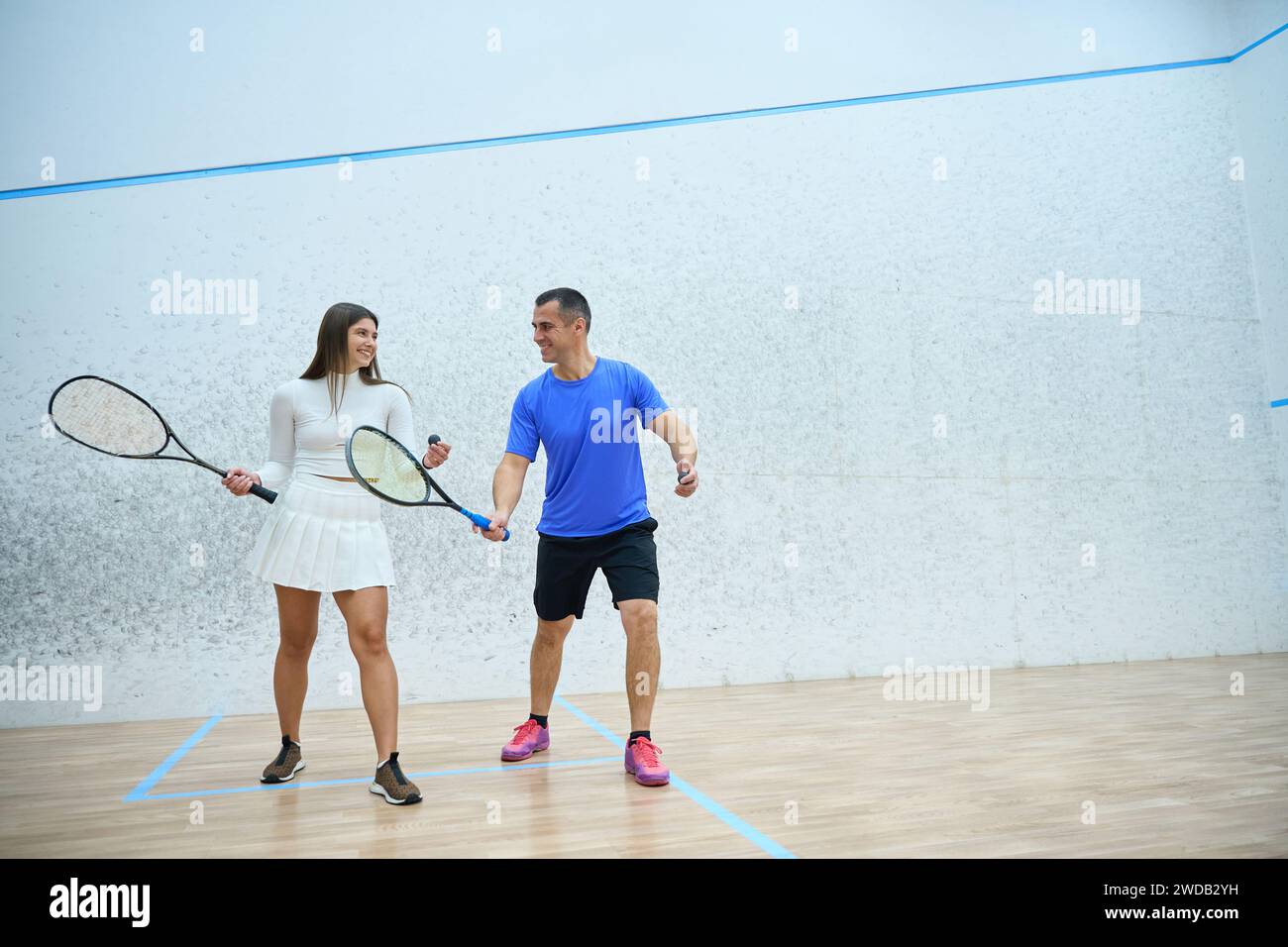 Energetic woman practices squash with man coach enhancing playing ...