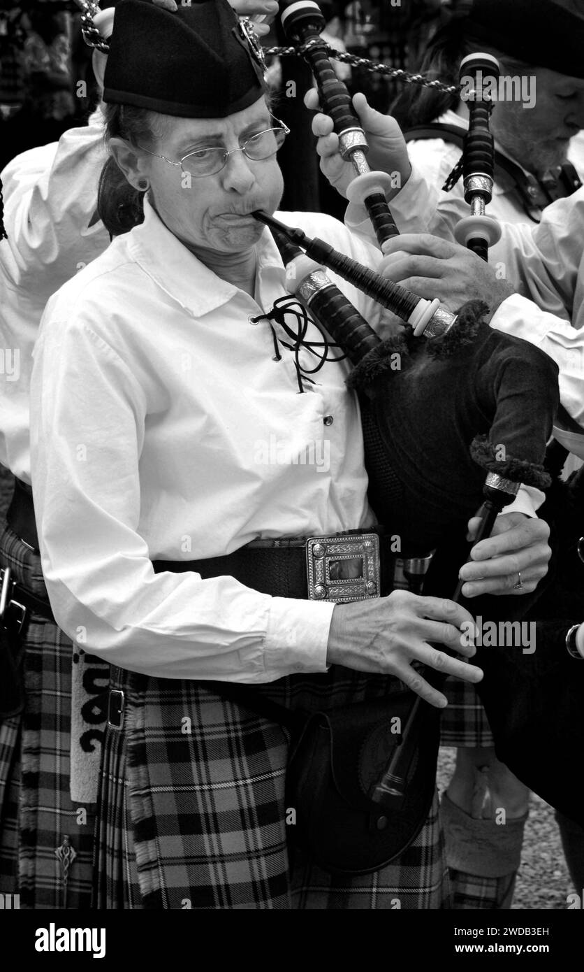 Musicians dressed in kilts and playing bagpipes participate in a parade ...