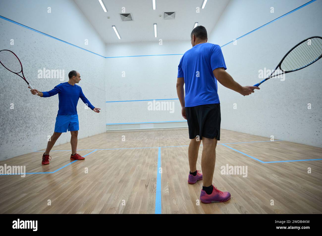 Sporty men playing squash showing their athletic skills on court Stock ...