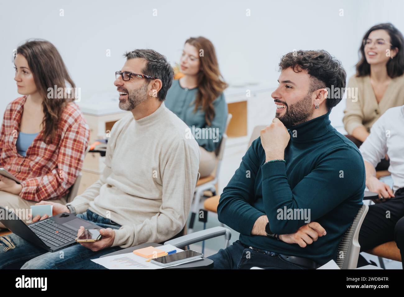 A multi generational, group of adult students with positive expressions ...