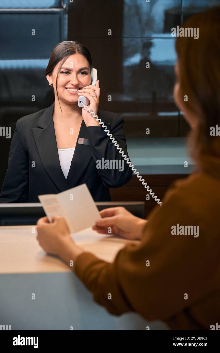 Cropped woman with passport and smiling female european receptionist ...