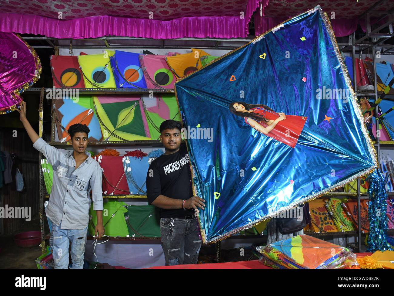 Ahmedabad, India. 13th Jan, 2024. Shopkeeper poses for a photo with a ...