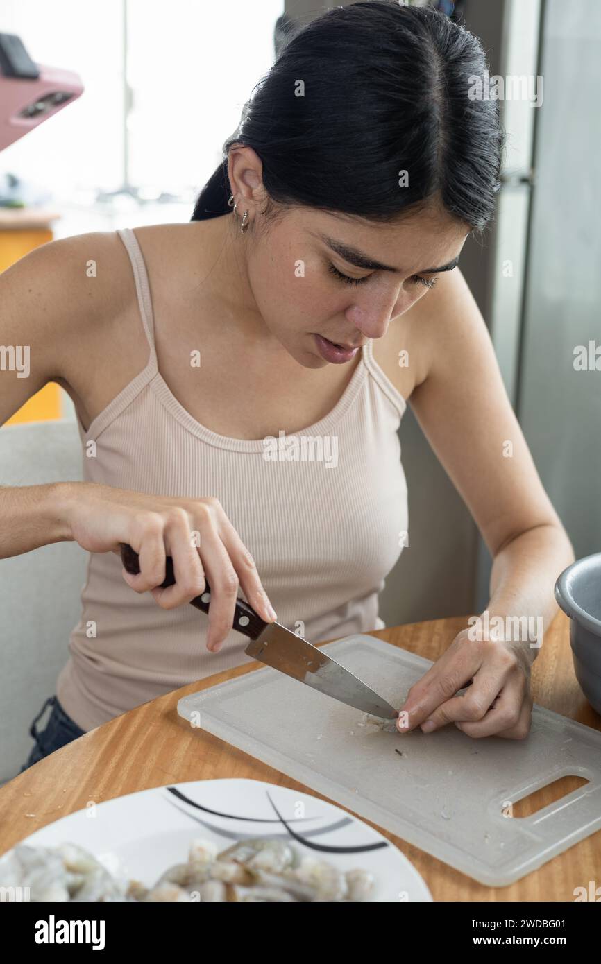 cutting shrimp with knife on cutting board, healthy food preparation ...