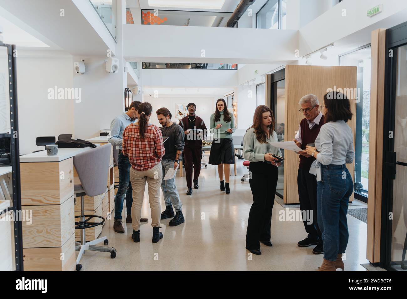 Multicultural team of employees engaging in a busy office workplace ...