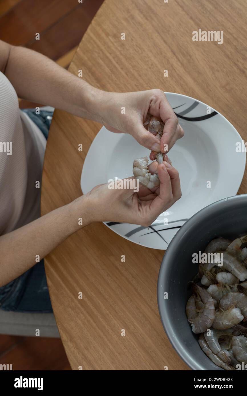 Sea food preparation details, peeling shrimp for food, workplace in ...