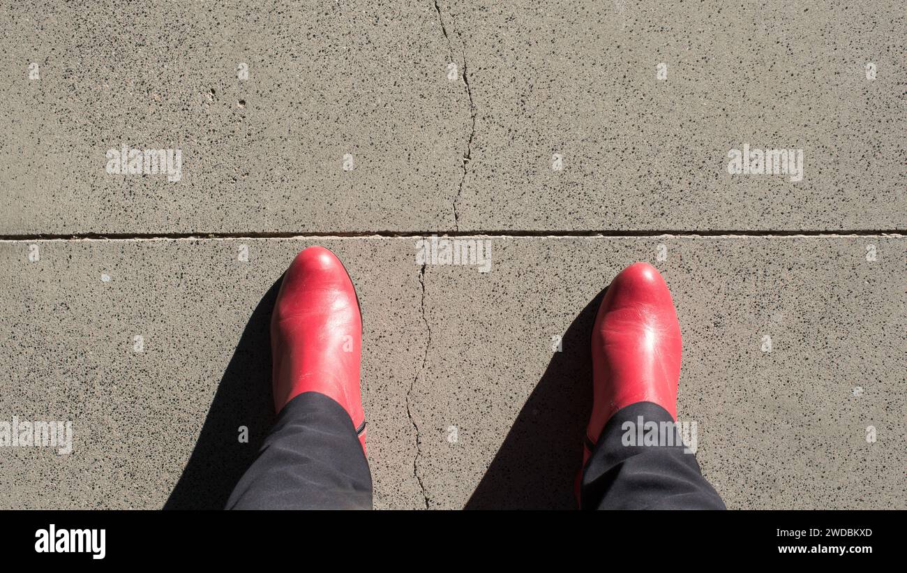 Woman wearing red boots, seen from above, about to cross a line Stock ...