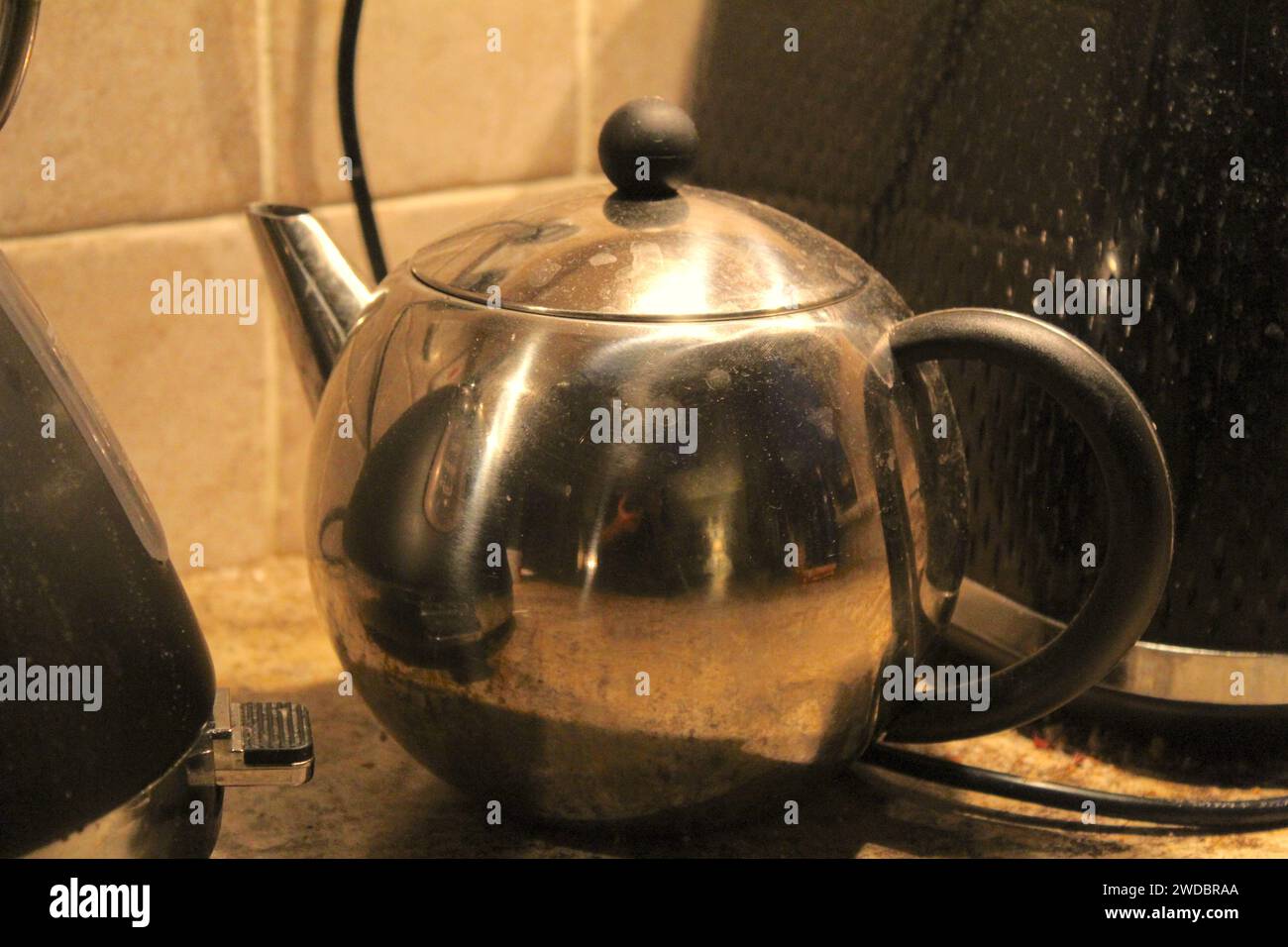 A close up photo of a metal kettle on a kitchen countertop Stock Photo ...