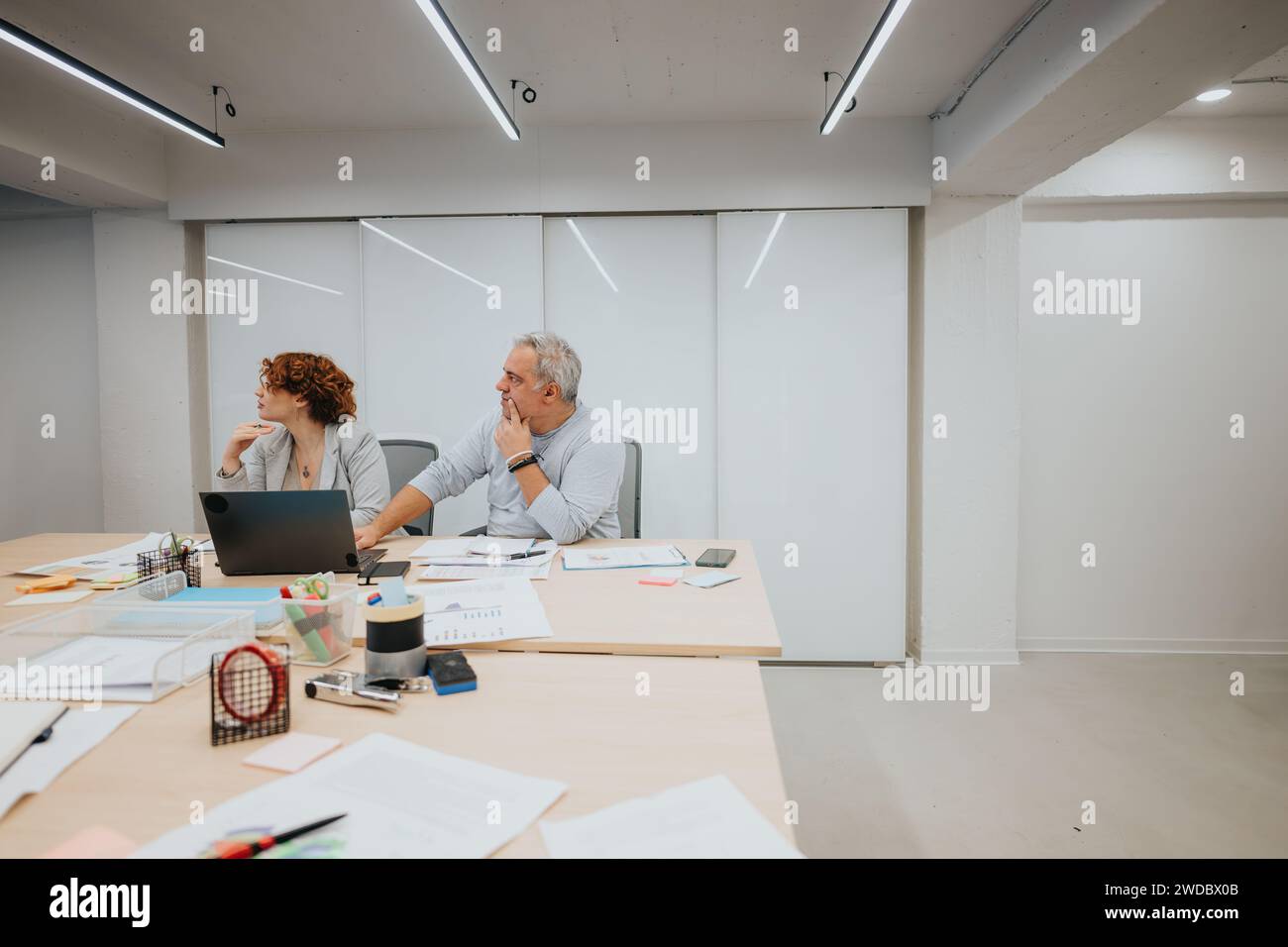 Cross generational employees collaborate in a classroom, discussing ...