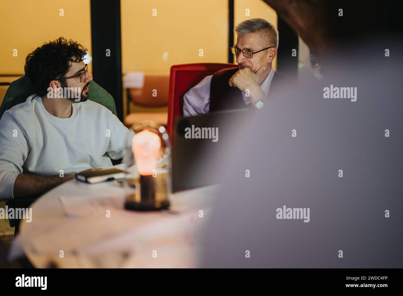 A multi generational team collaborating in an office meeting for ...