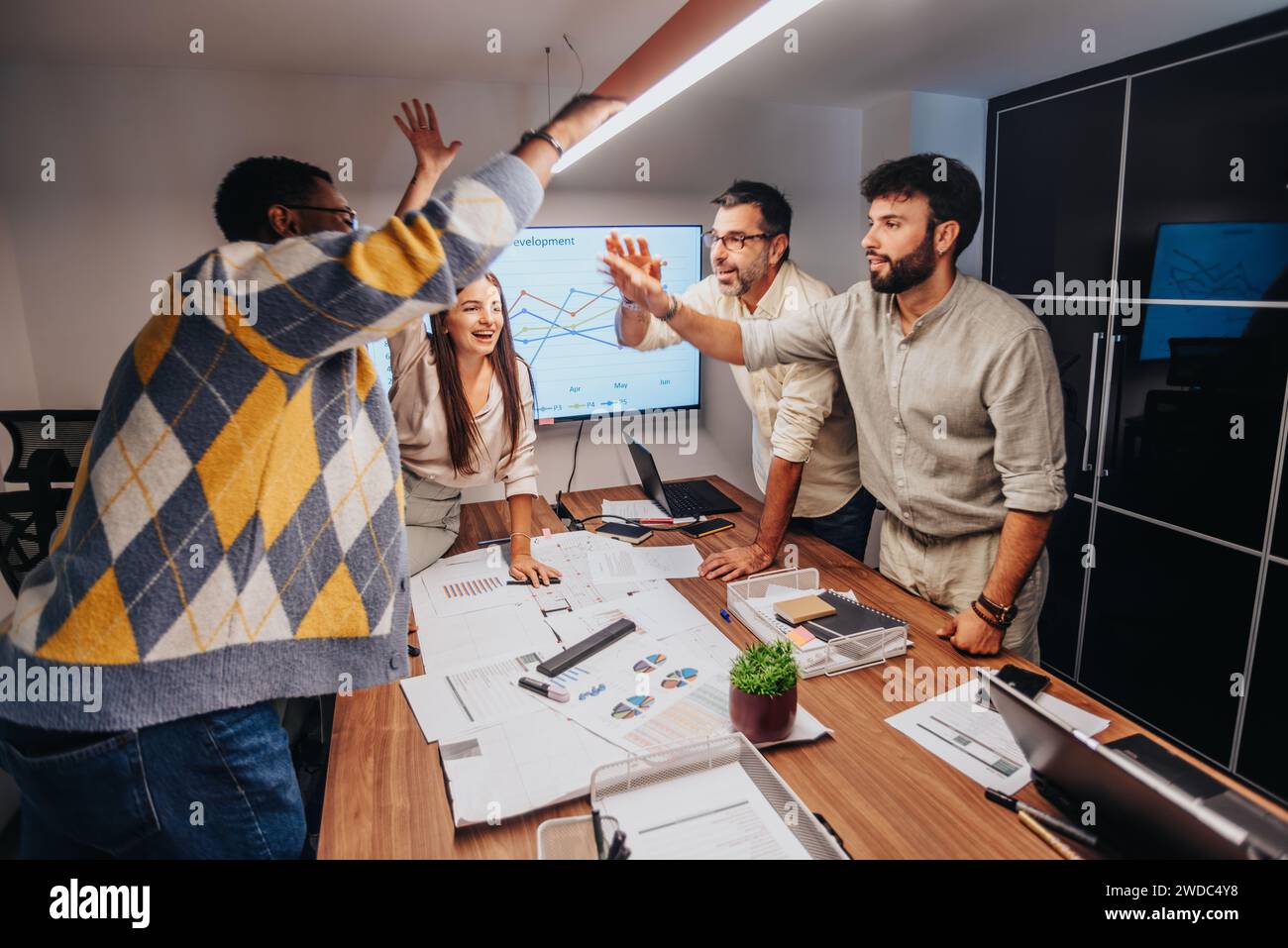 Multinational team collaborates in a board room, discussing ...