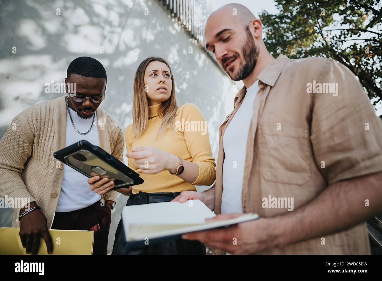Young team of executives collaborates outdoors in an urban city ...