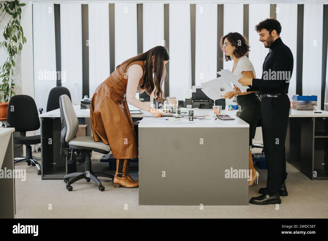 Team of three professionals collaborating with papers in a modern ...