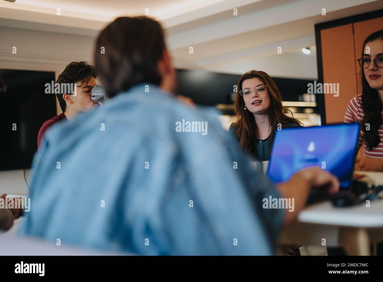 Creative team engaging in discussion at modern office workspace Stock ...