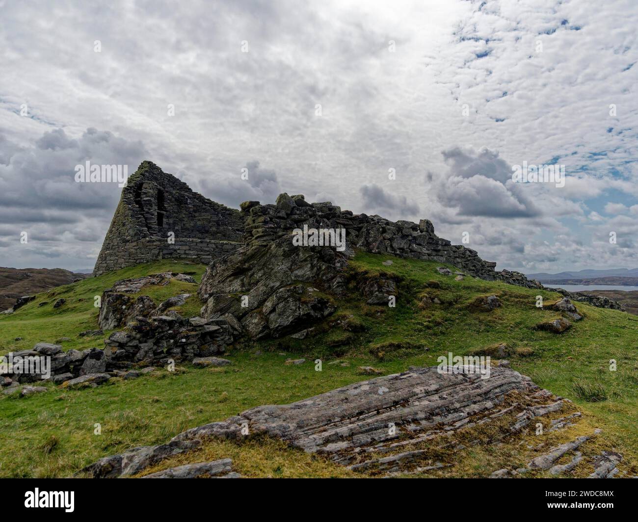 Ruined structure on rocky ground under a dramatic cloudy sky, ruins of ...