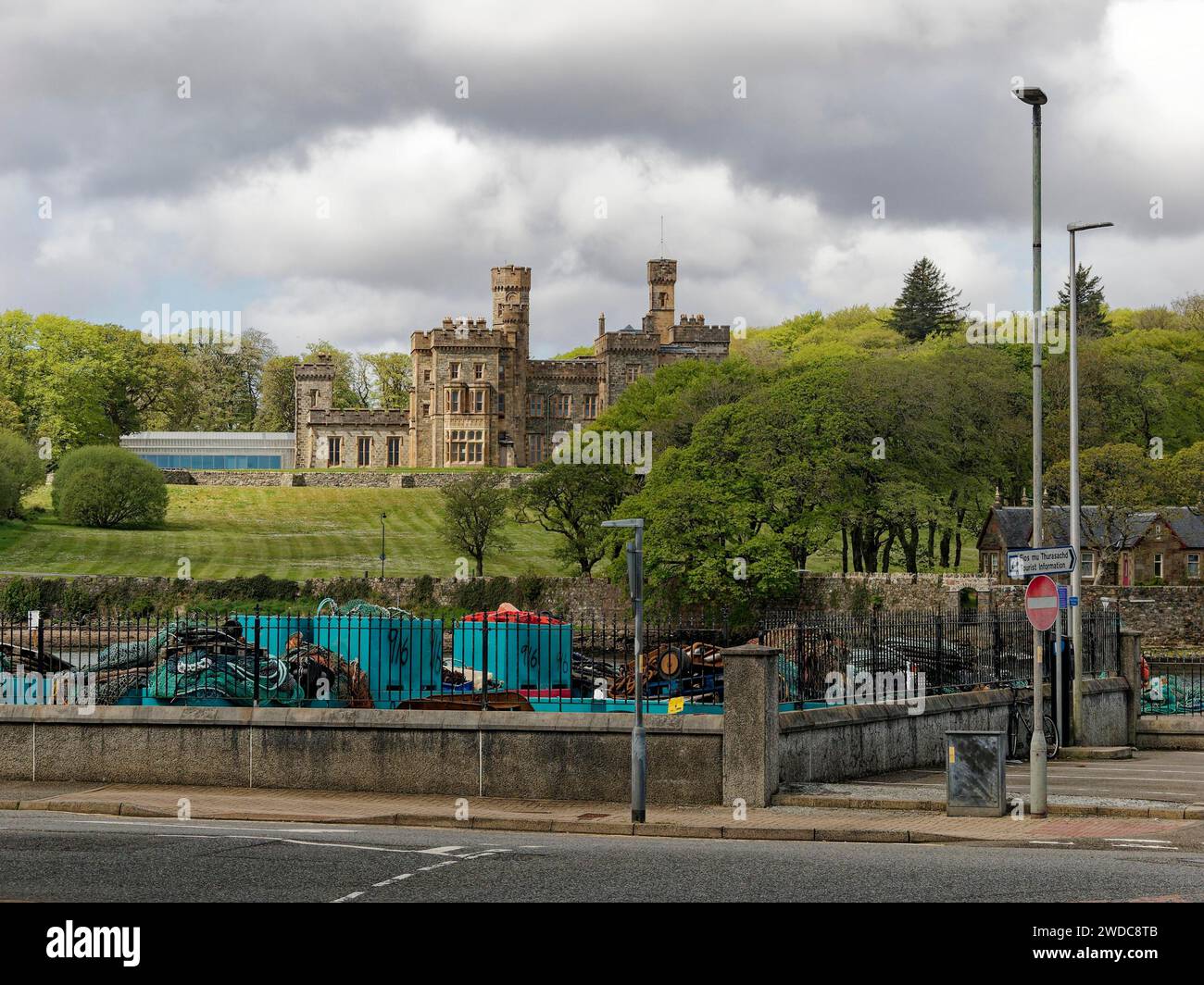 Historic castle behind a fence on a hill surrounded by trees under a ...