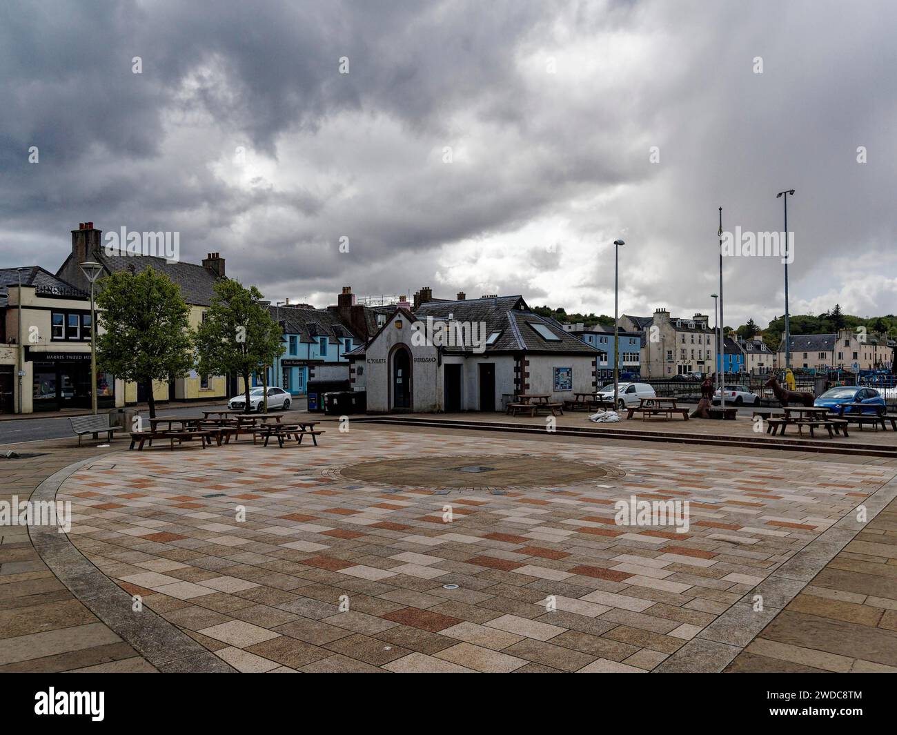 Empty town square with cobblestones, surrounded by buildings under a ...