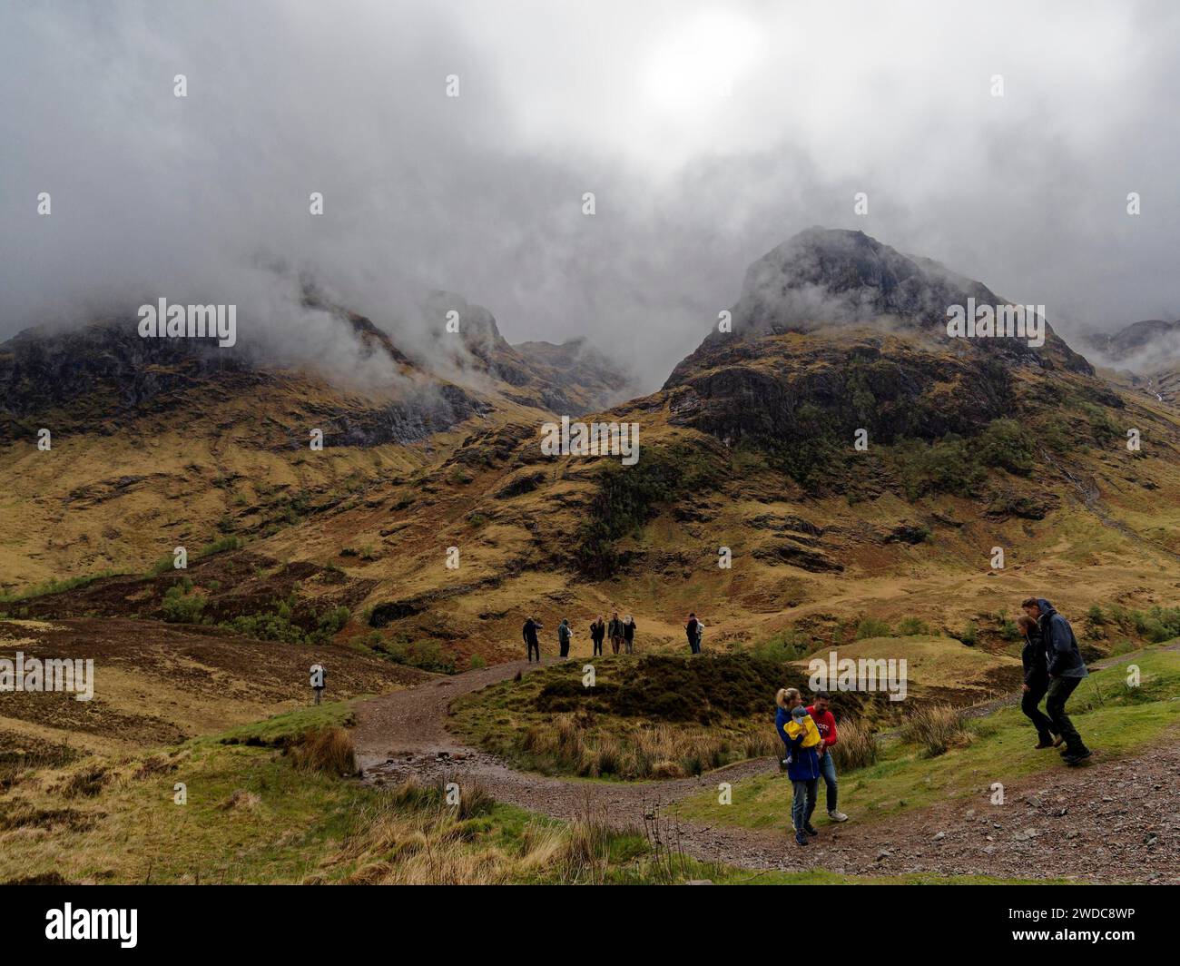 People in front of mountainous, misty landscape with hills Three ...
