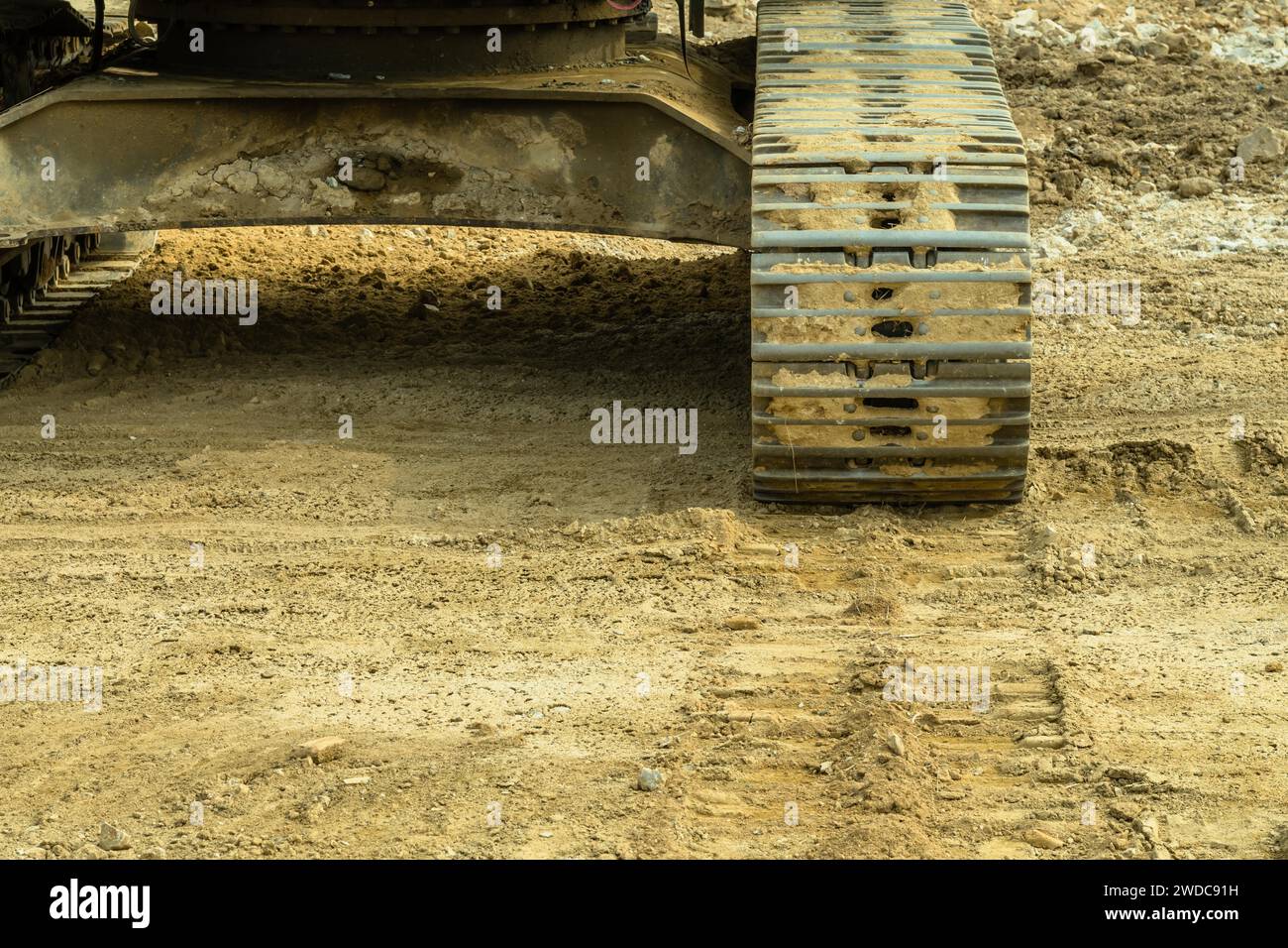 Front view of tracks and undercarriage of backhoe at construction site ...