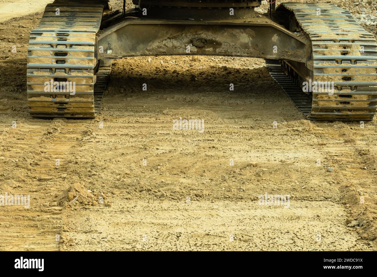 Front view of tracks and undercarriage of backhoe at construction site ...