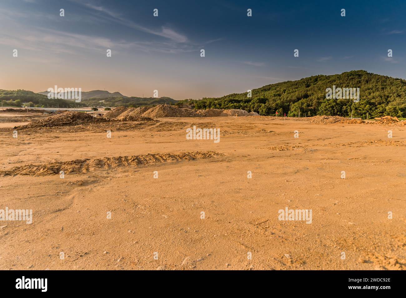 Barren area of land that has been cleared for development with lush ...