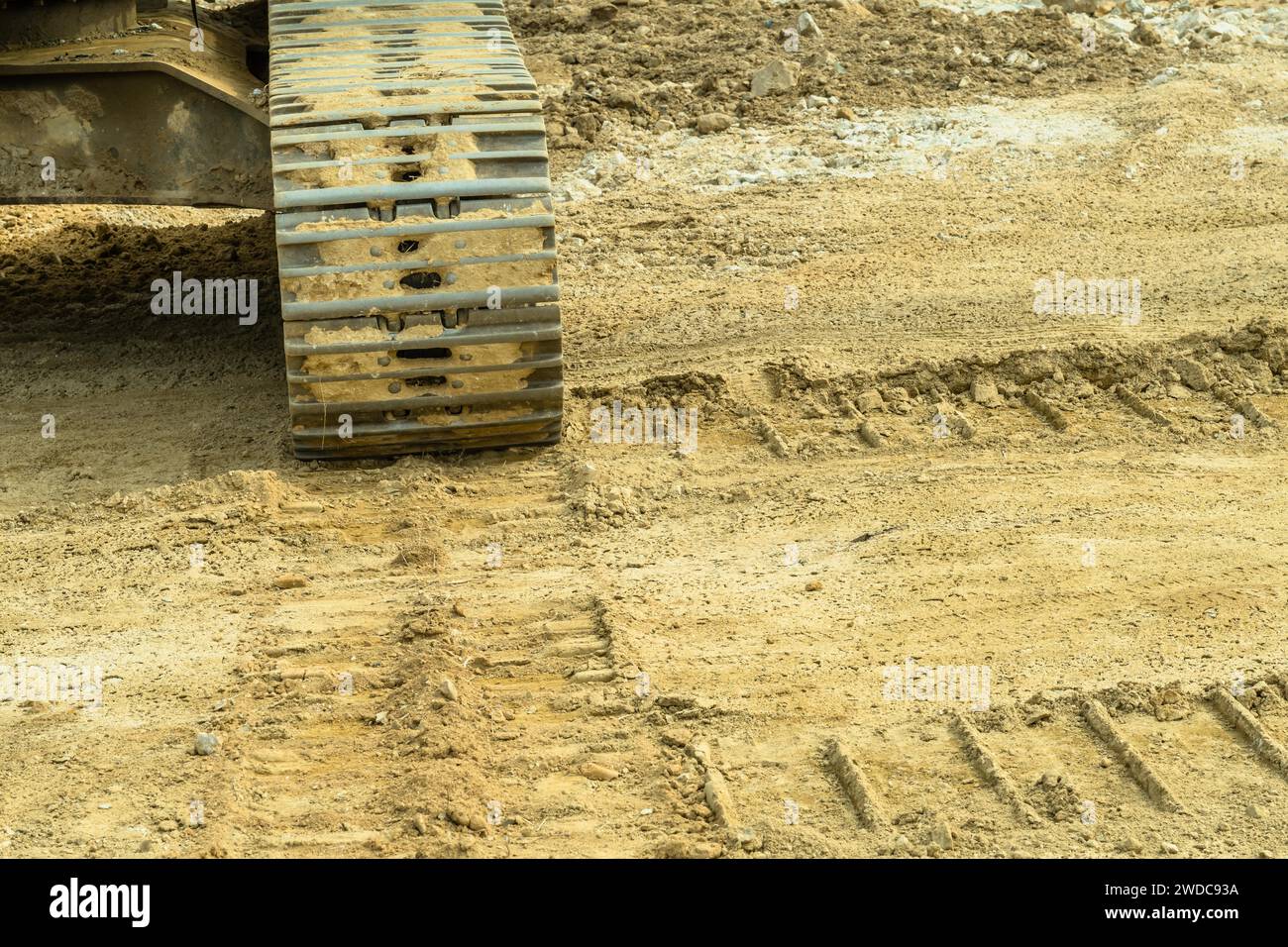 Front view of tracks and undercarriage of backhoe at construction site ...
