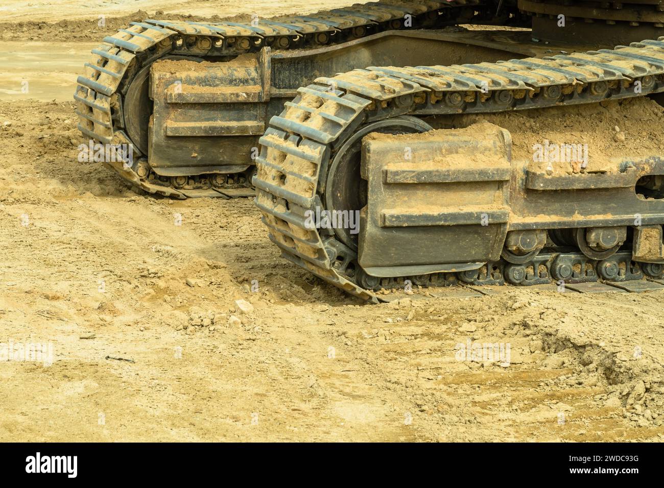 Side and front view of backhoe tracks and wheel assembly at rest at ...