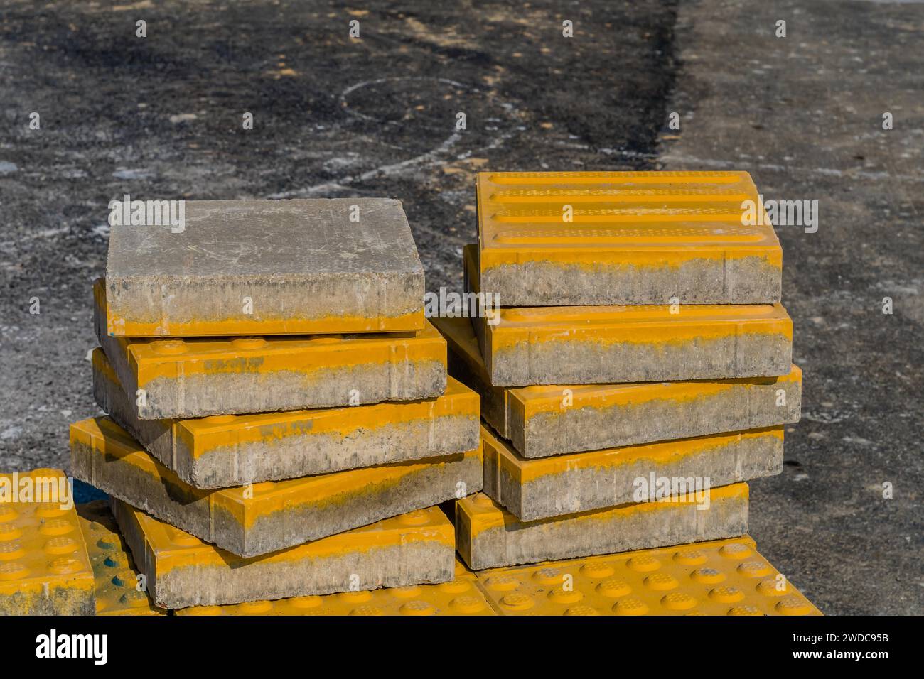 Square preformed concrete blocks with one side painted yellow to be ...