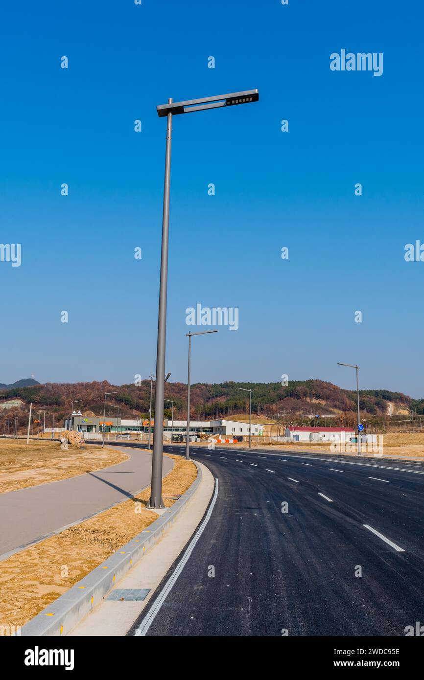 New rectangle LED streetlights on paved street running through new ...
