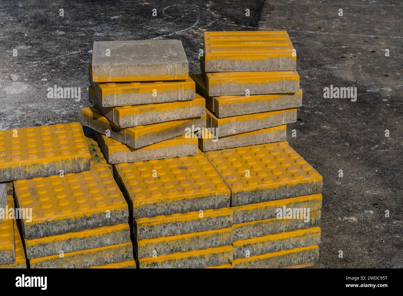 Square preformed concrete blocks with one side painted yellow to be ...