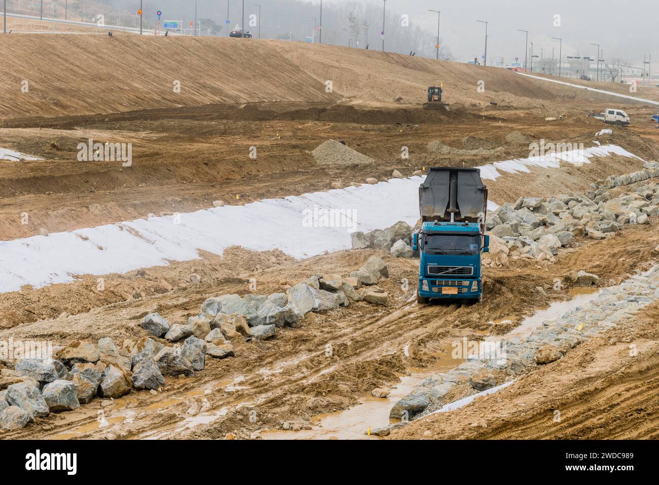 Blue dump truck in muddy man made ravine at new construction site ...