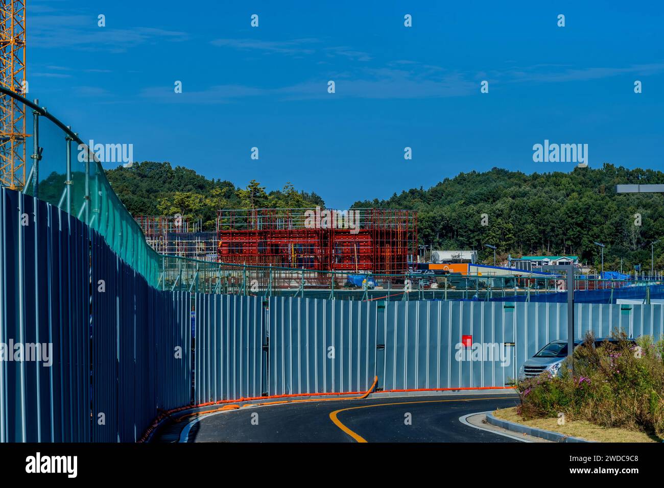 Metal frame of new structure behind gray fence at construction site ...