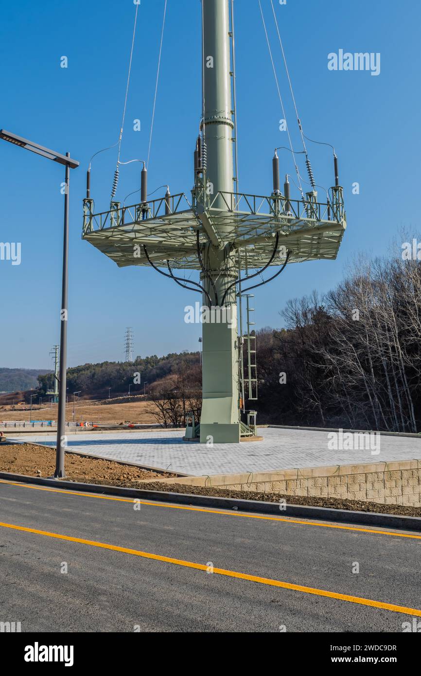 Large electrical tower on concrete foundation on sunny day, South Korea ...