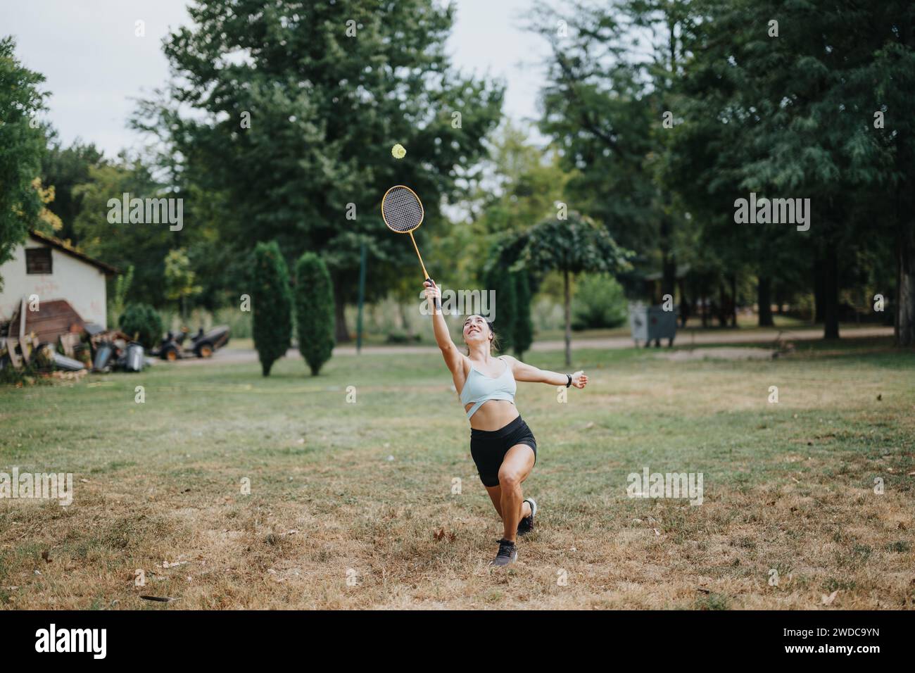 Friends playing badminton in a sunny park. Attractive athletes showing ...