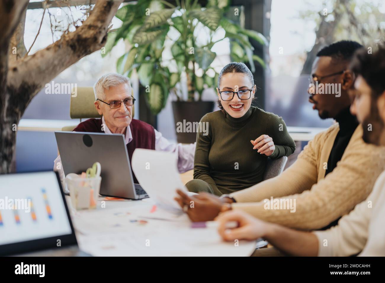 Multi generational team of coworkers discussing business growth and ...