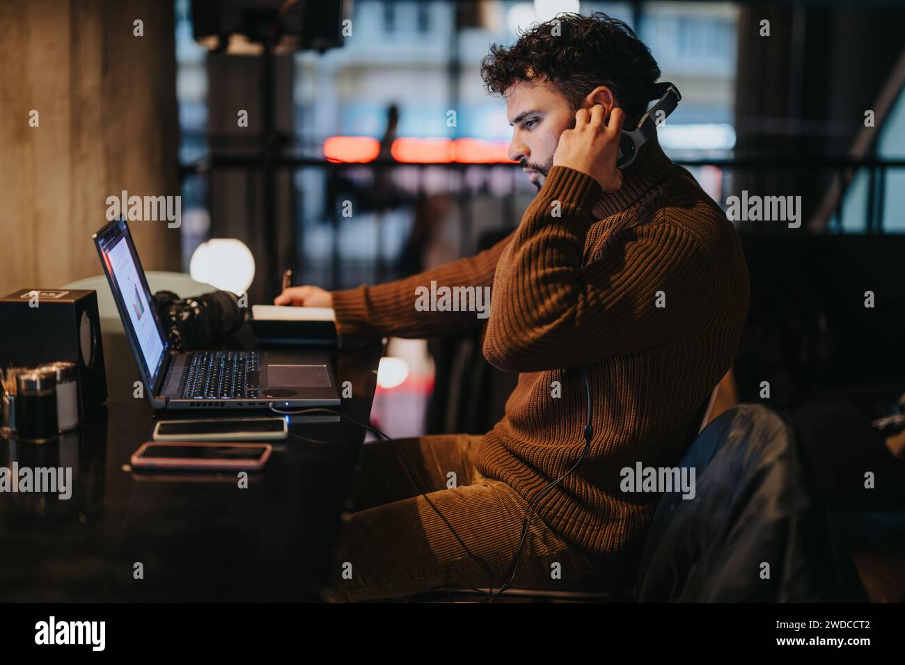 Business person working alone in an office at night, discussing project ...