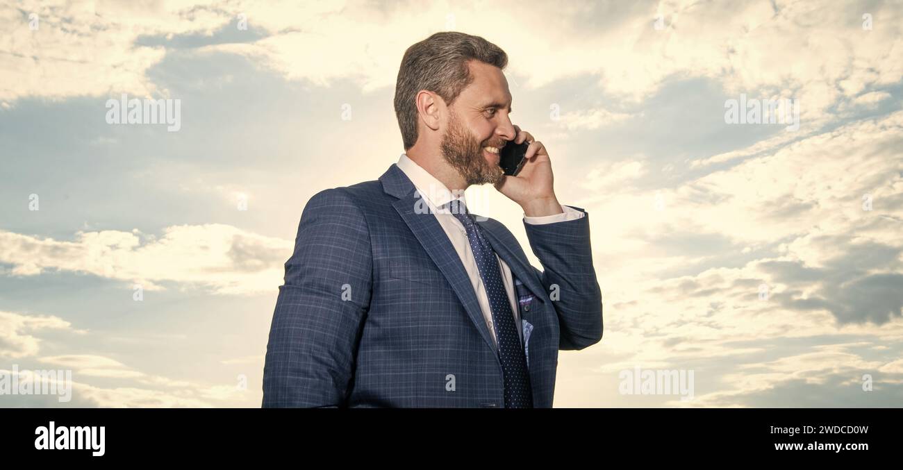 cheerful man has phone talk on sky background. man has phone talk ...