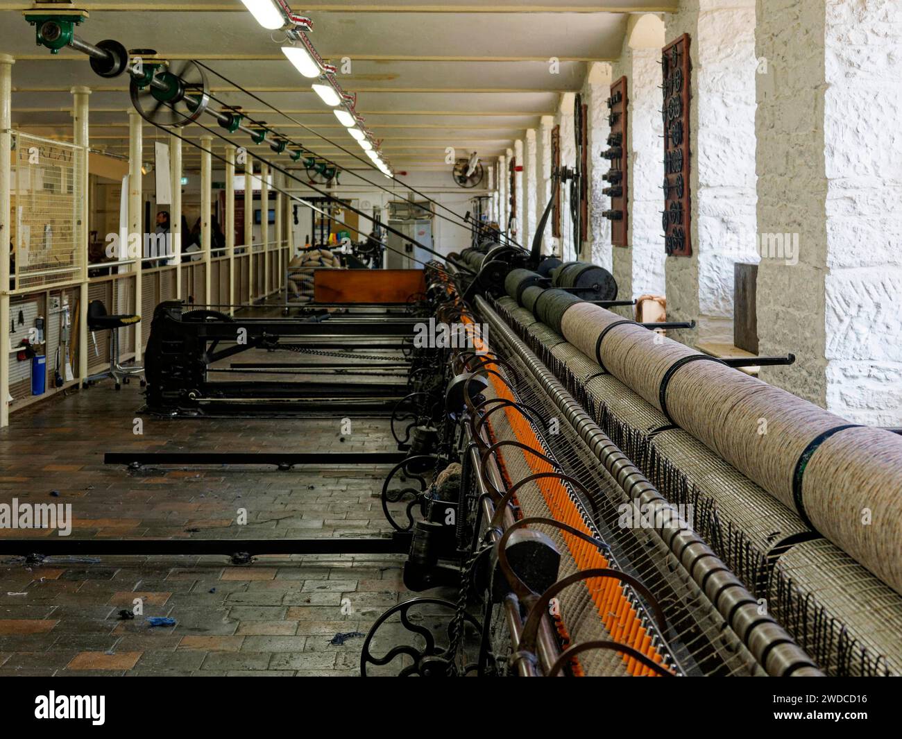 Interior view of an old industrial factory with rows of looms and ...