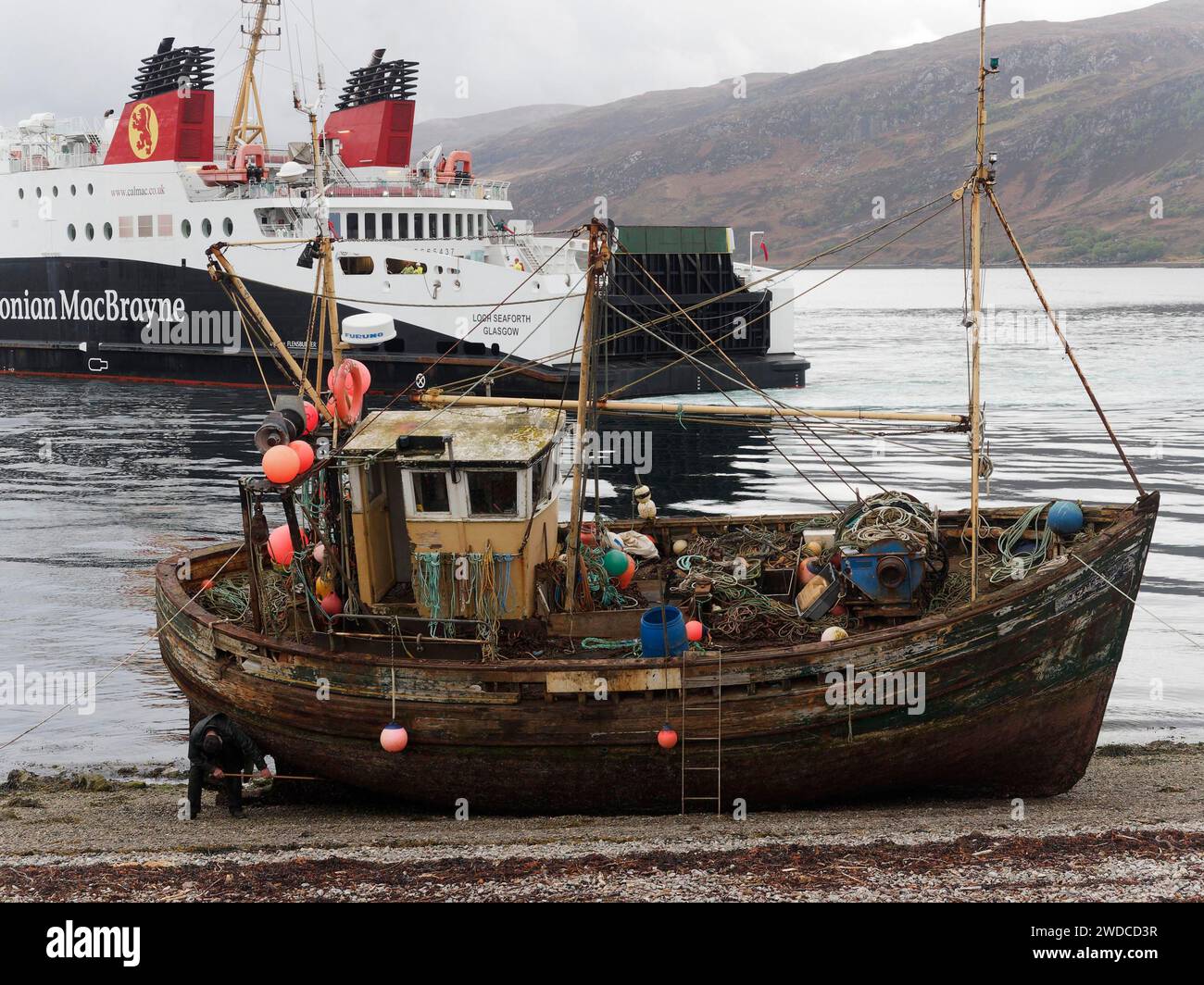 Ship cutter on land in front of ferry in Ullapool harbour. Scotland ...