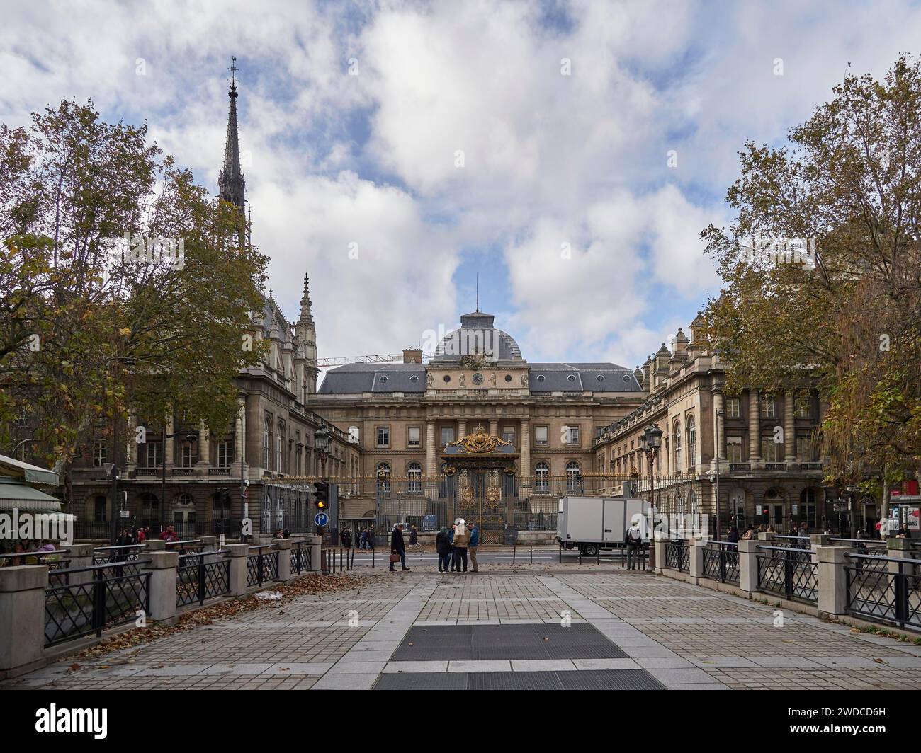 A view of an elegant palace with walkers on a path surrounded by ...