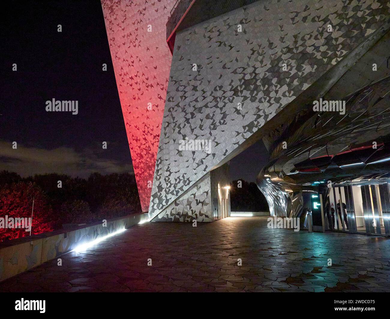 A futuristic building at night with striking red lighting and patterns ...