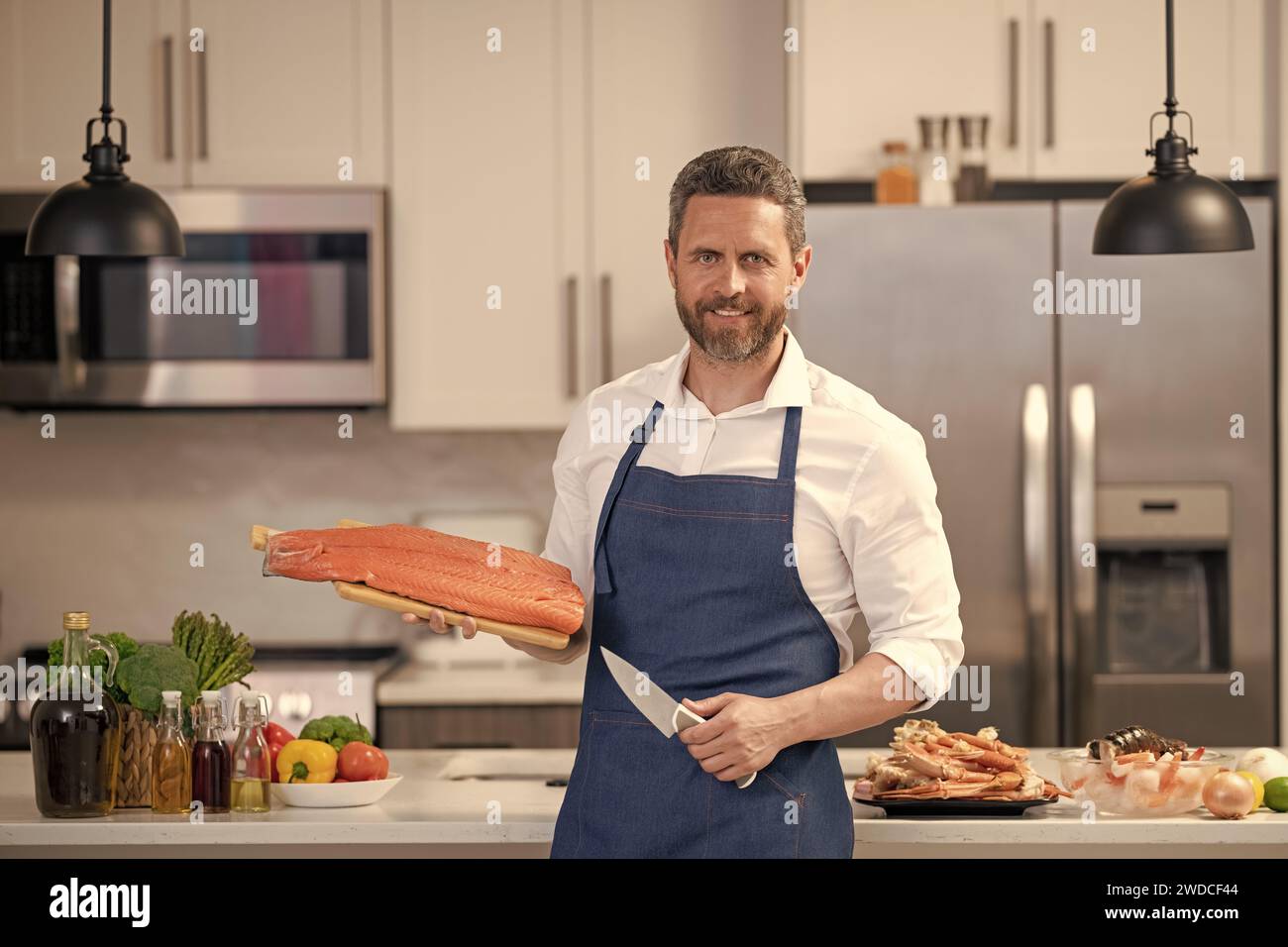 positive man cook delicacy salmon fish. man cook delicacy salmon in the ...
