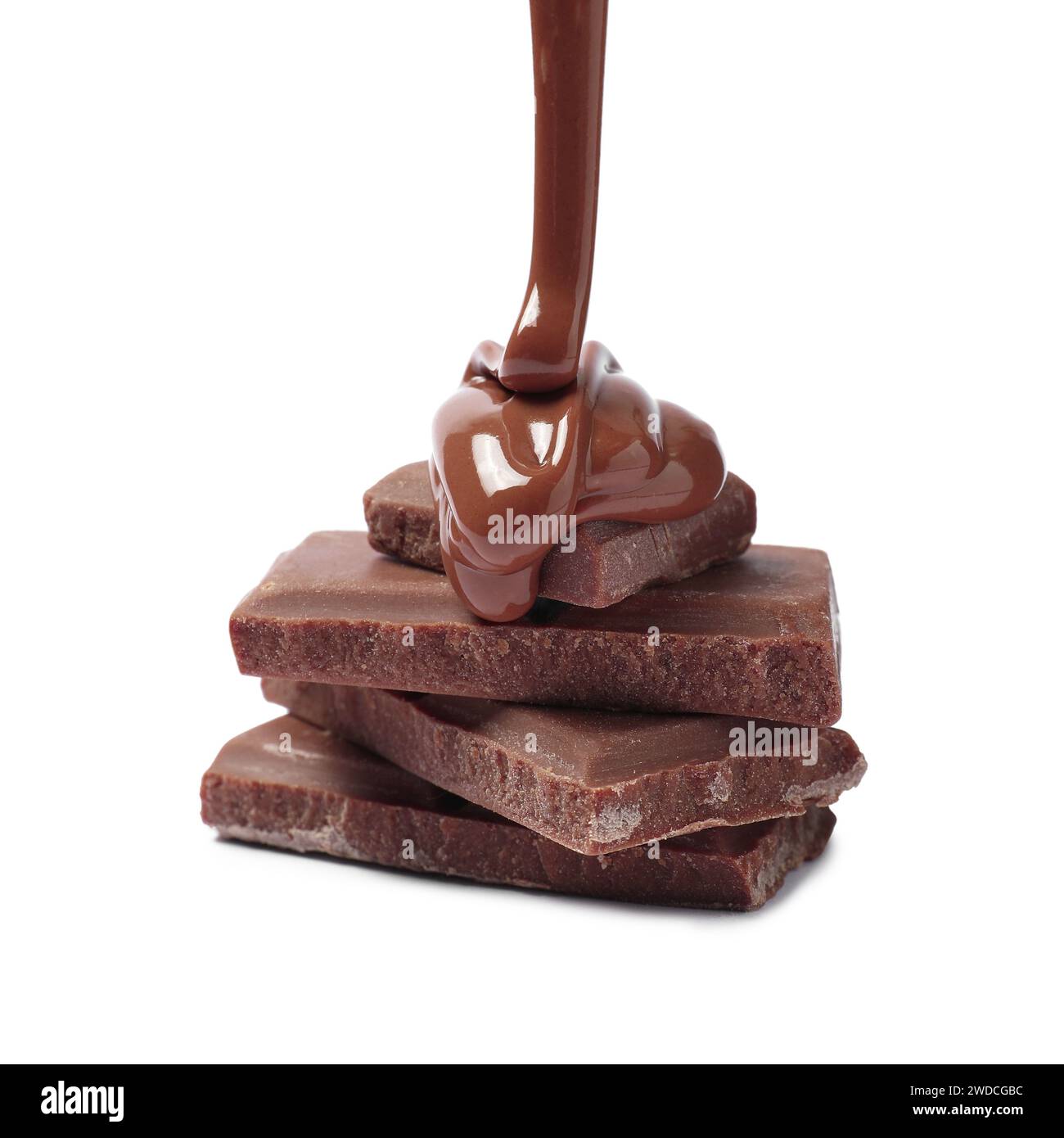 Pouring tasty milk chocolate paste onto pieces isolated on white Stock ...