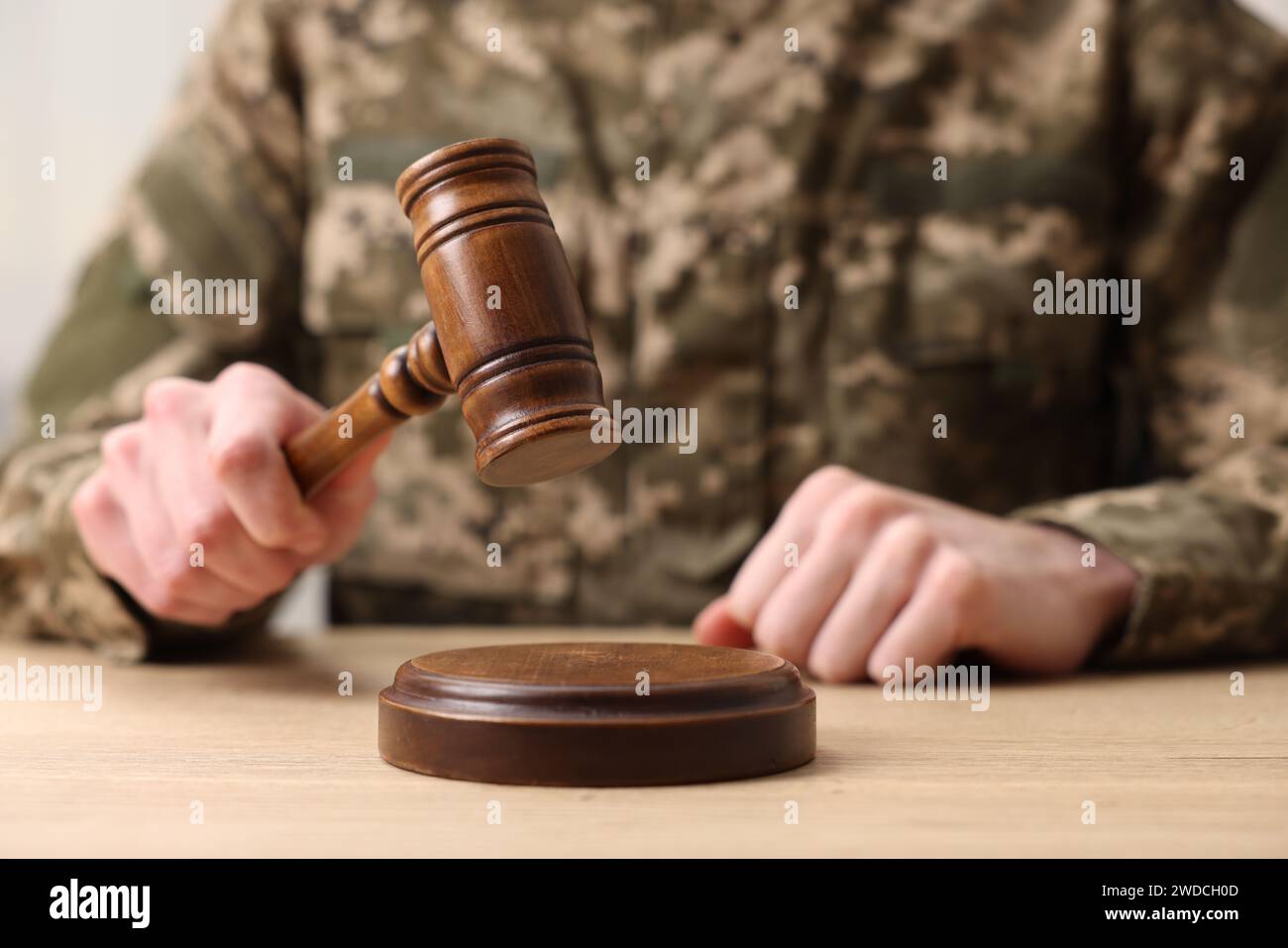 Law concept. Man in military uniform with gavel at wooden table ...