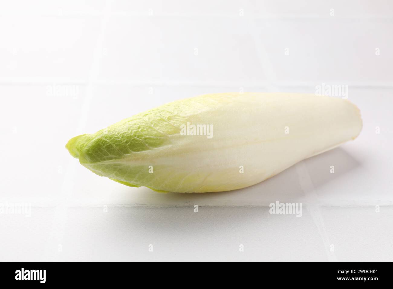 Fresh raw Belgian endive (chicory) on white tiled table Stock Photo - Alamy