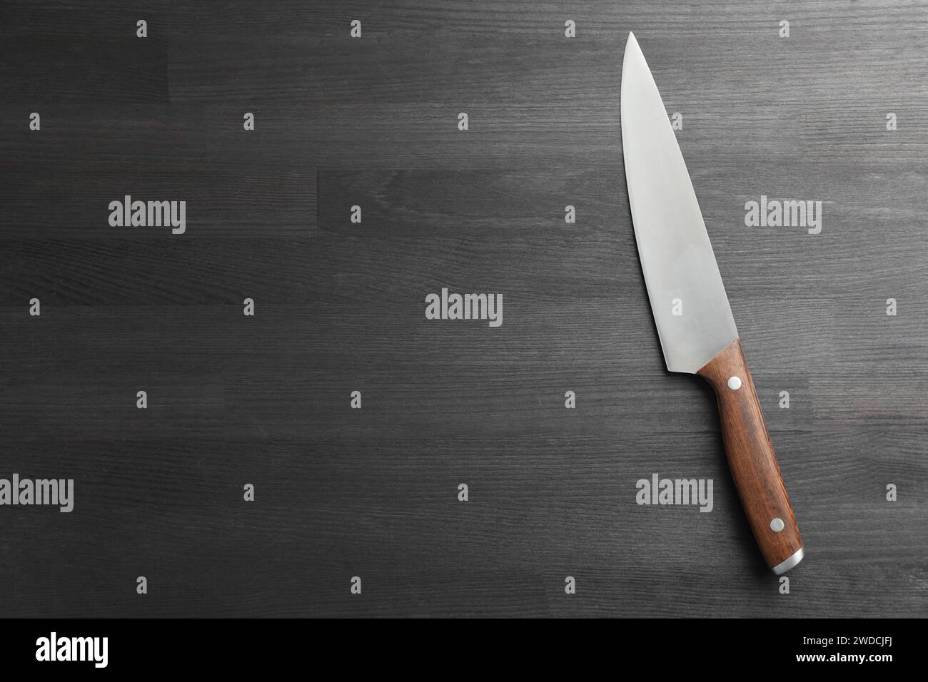One sharp knife on black wooden table, top view. Space for text Stock ...