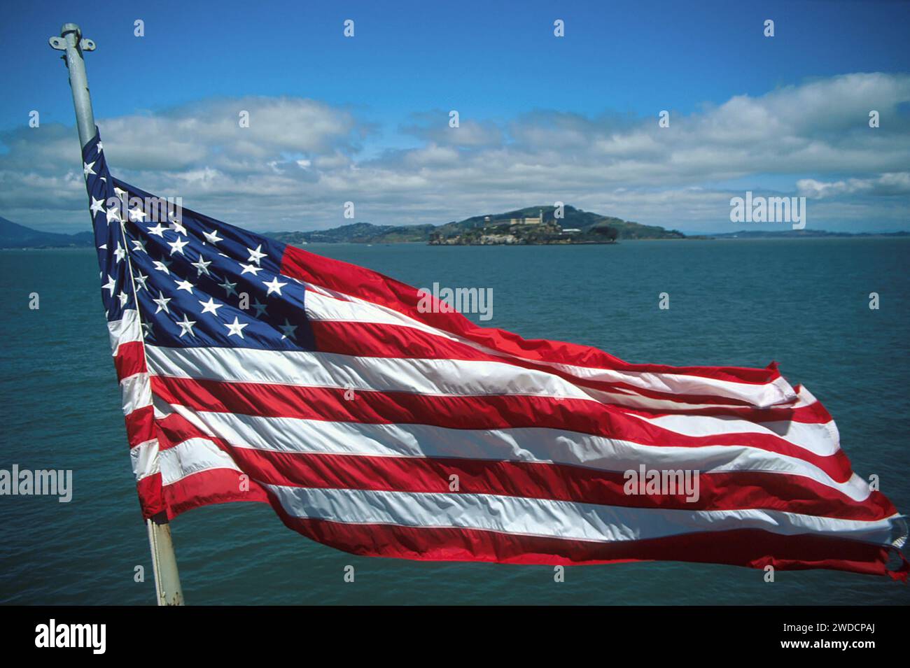 American flag with Alcatraz Island prison in background, taken in 2000, San Francisco ...