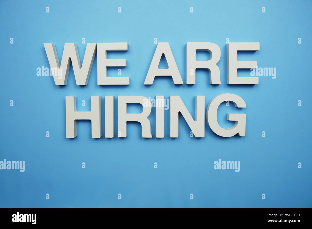 We are Hiring alphabet letters on blue background Stock Photo - Alamy