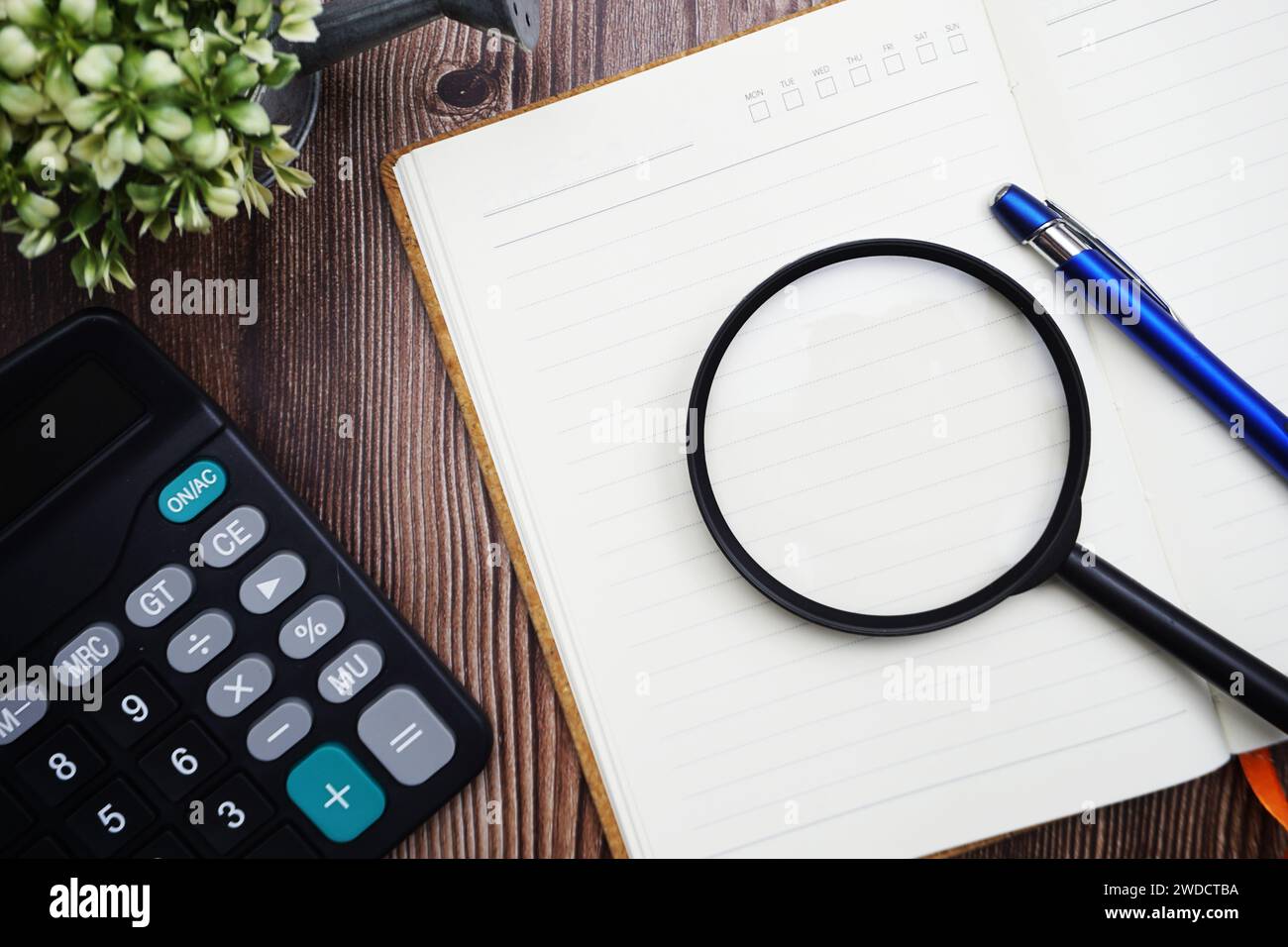 Planning schedule with magnifying glass and calculator on wooden ...