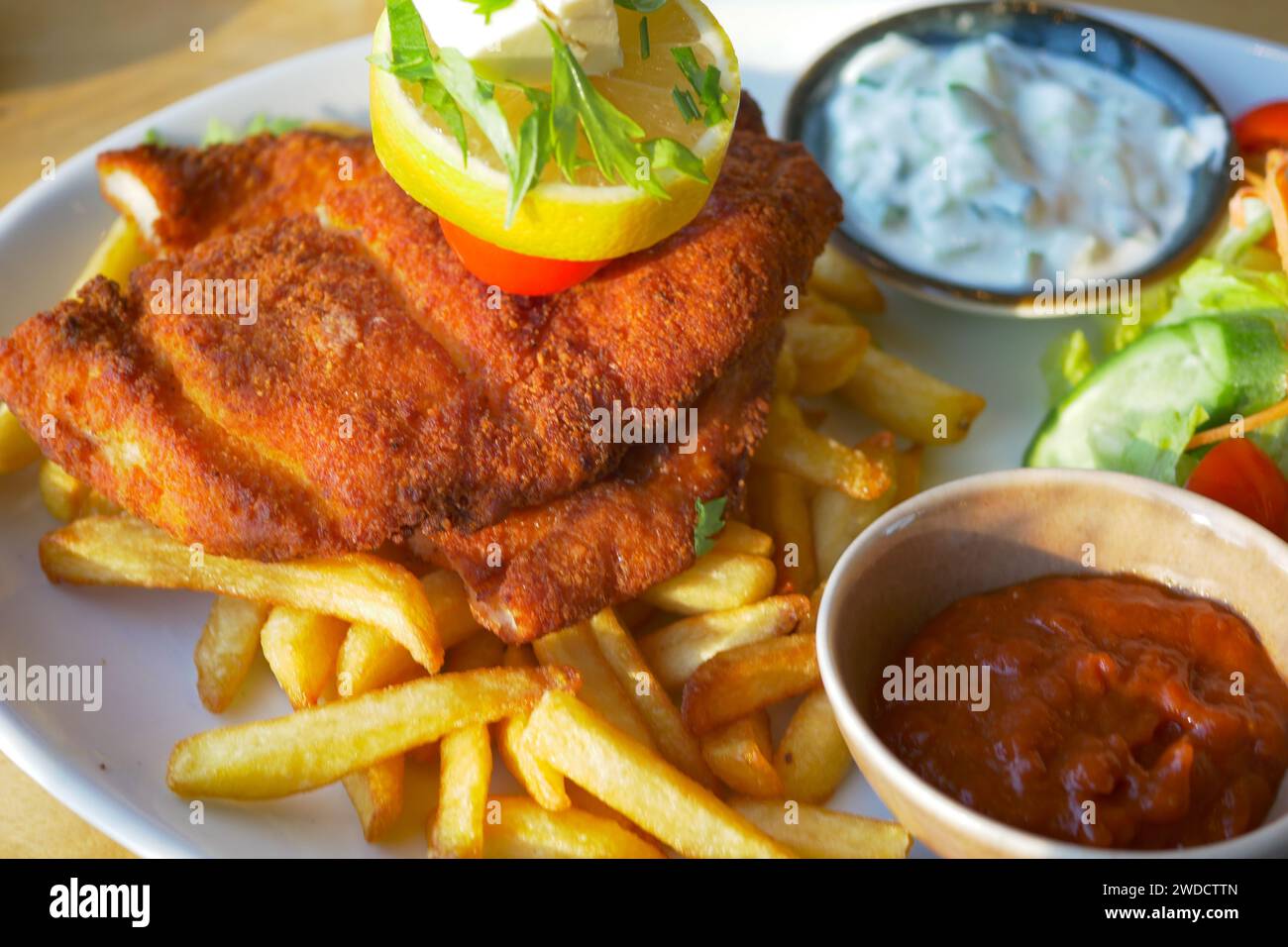 Chicken schnitzel served with potato chips Stock Photo - Alamy